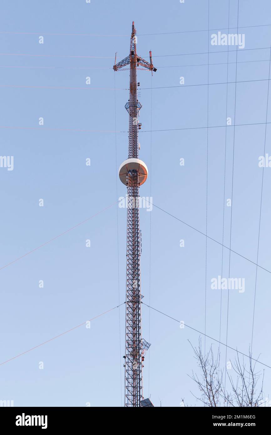 tall communications tower and cables soaring overhead into blue sky Stock Photo - Alamy