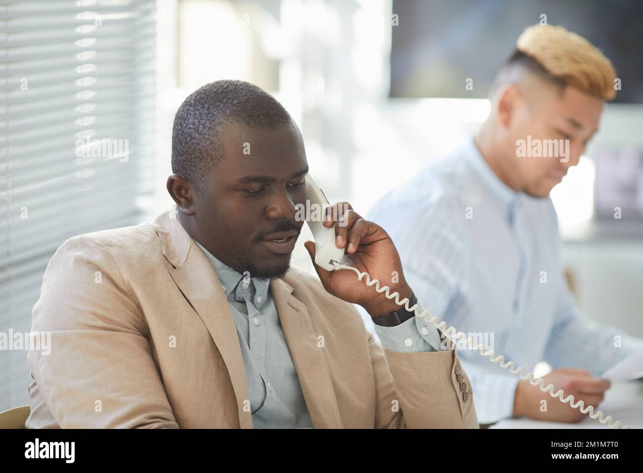 Portrait of black man speaking on phone while advising customer in call ...