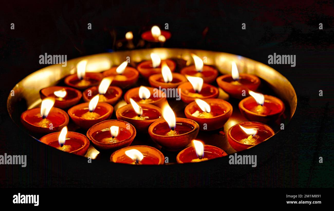 Many Diya or traditional clay lamps on Diwali festival. A girl hand ...