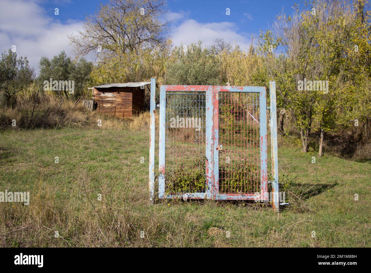 Image of an isolated old gate without a fence with an abandoned shack ...
