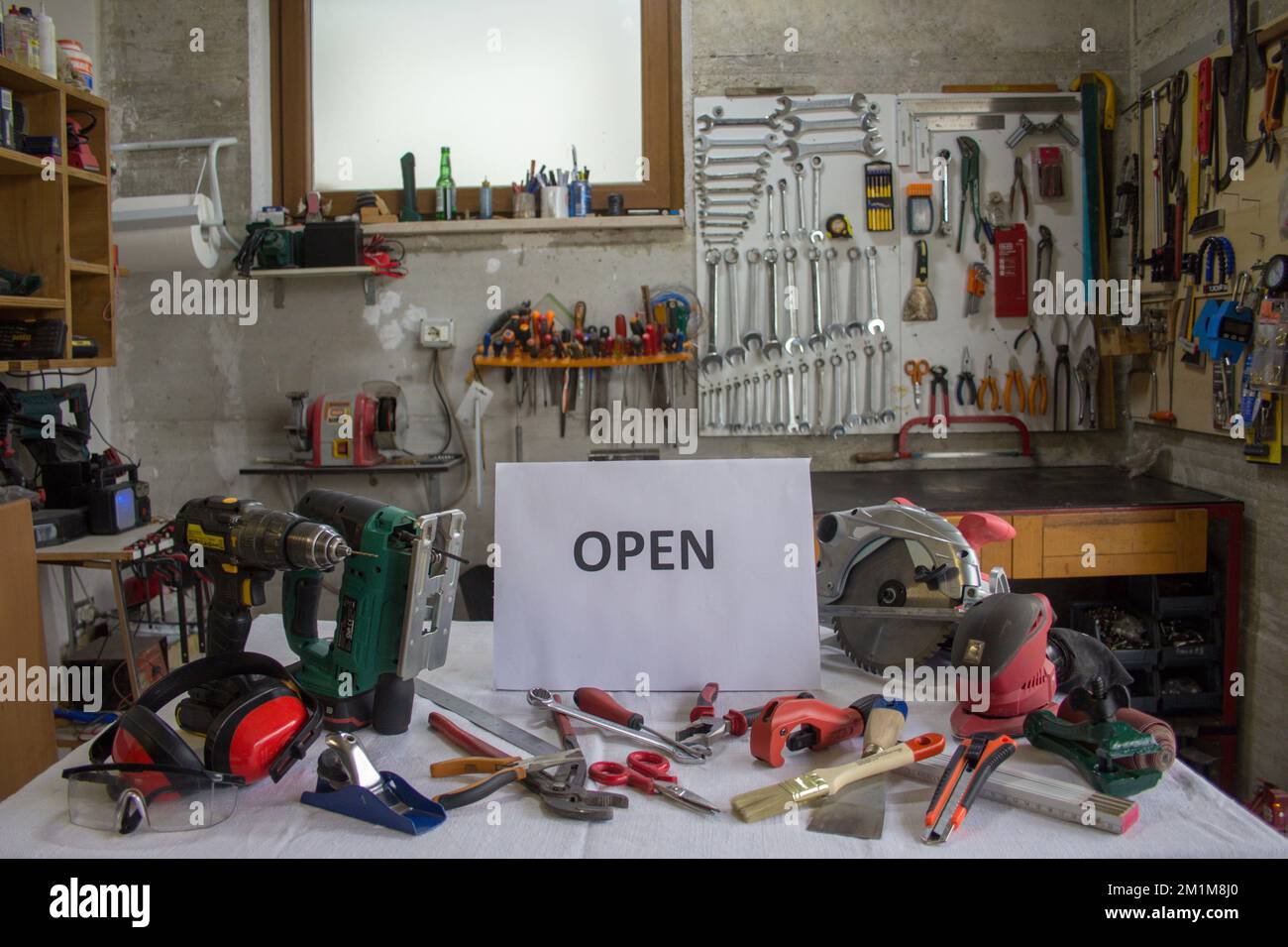 Image of a workshop with a workbench full of tools and an OPEN sign ...
