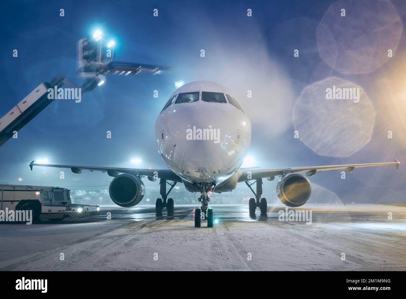 Deicing of airplane before flight. Winter night at airport during ...