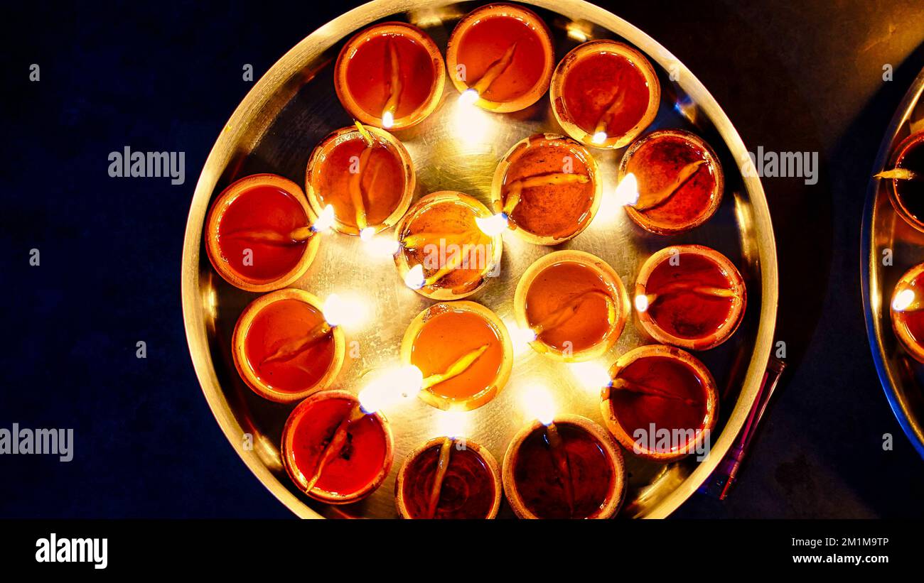 Many Diya or traditional clay lamps on Diwali festival. A girl hand ...