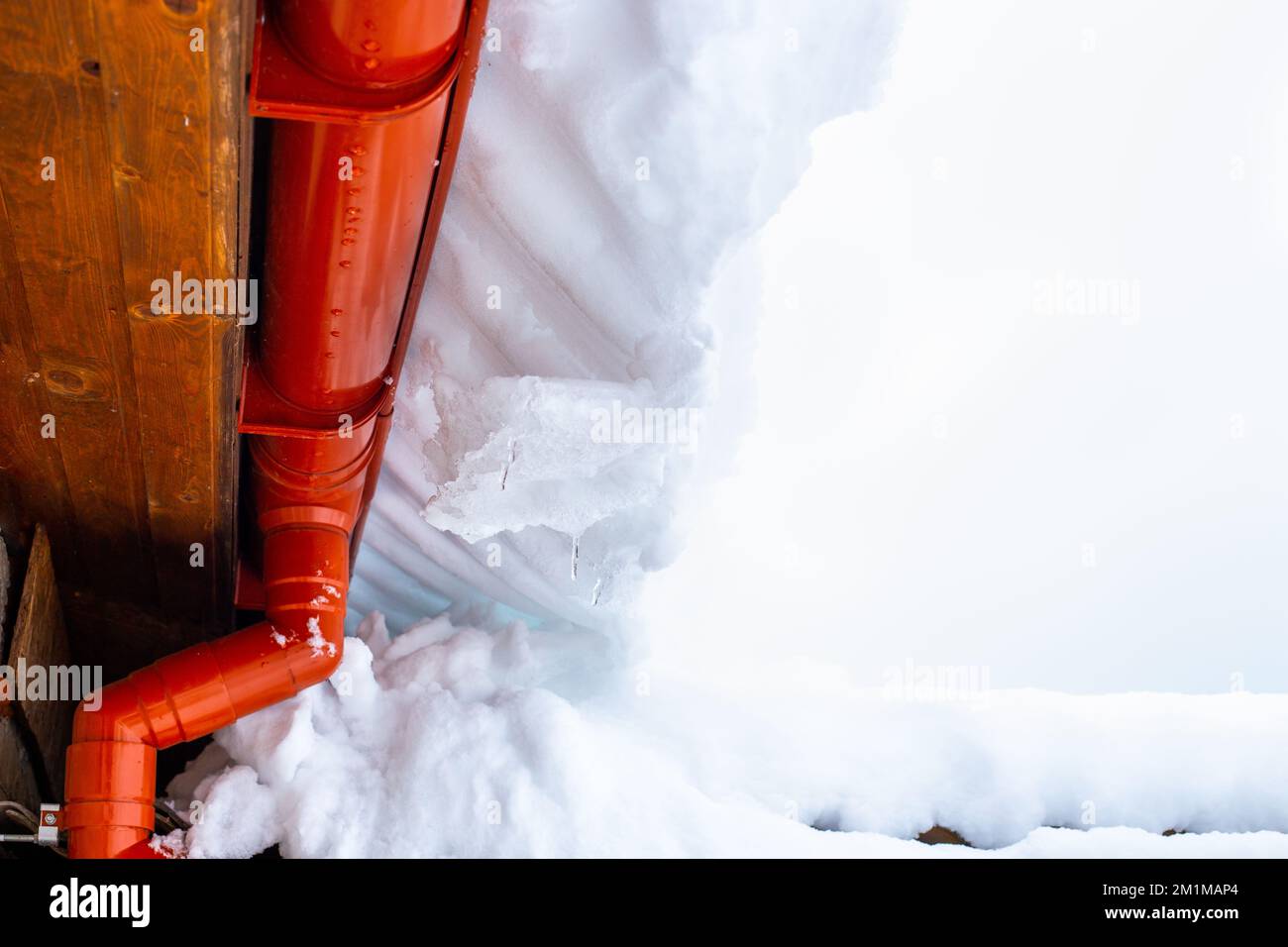 The descent from the roofs of the snow. A large snowdrift of melting ...