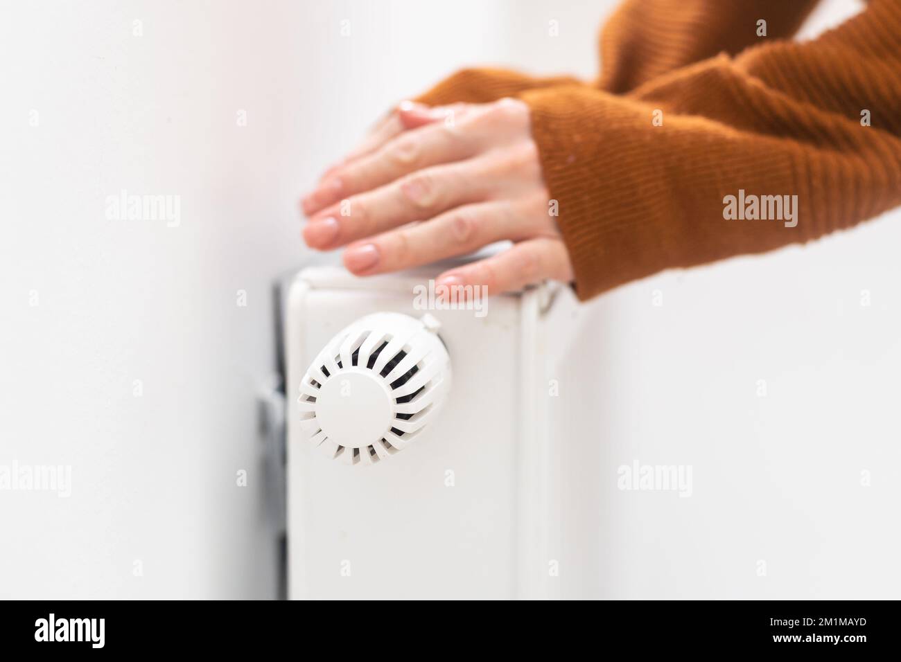 hand adjusting radiator temperature using thermostat. Home with central ...
