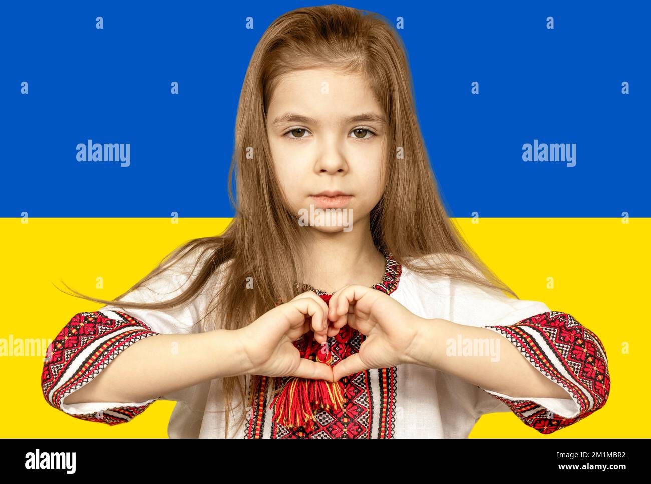 A girl in national Ukrainian clothes, an embroidered shirt, shows a ...