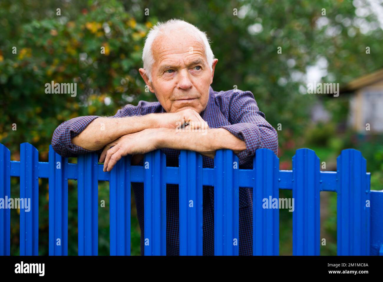Old man leaning on fence outdoors Stock Photo - Alamy
