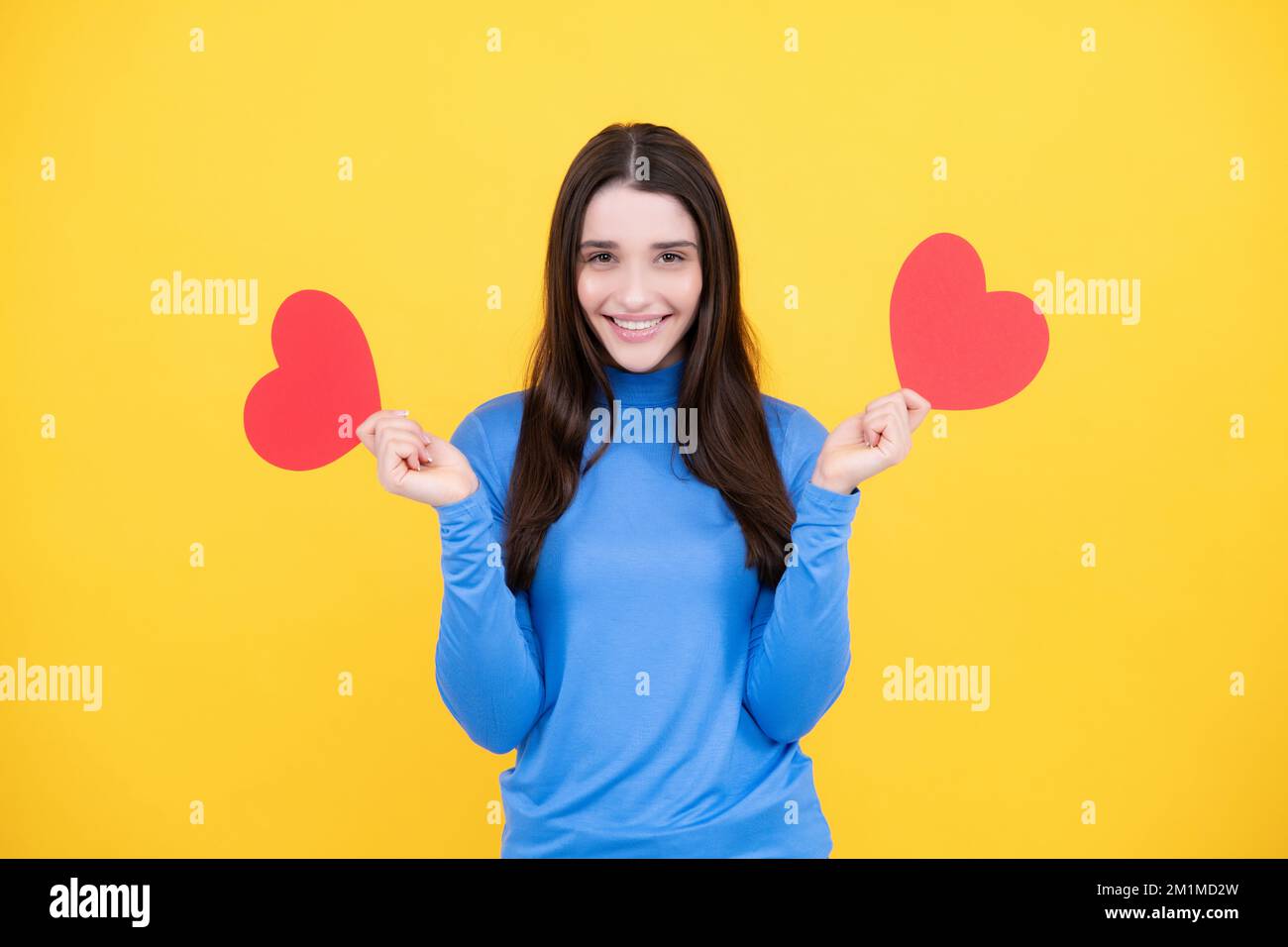 Happy woman hold red heart. Beautiful female model posing on isolated ...