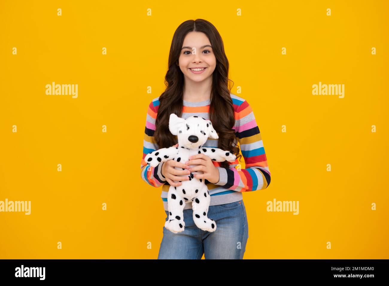 Teenager girl 12, 13, 14 year old hold soft toy for birthday on yellow ...