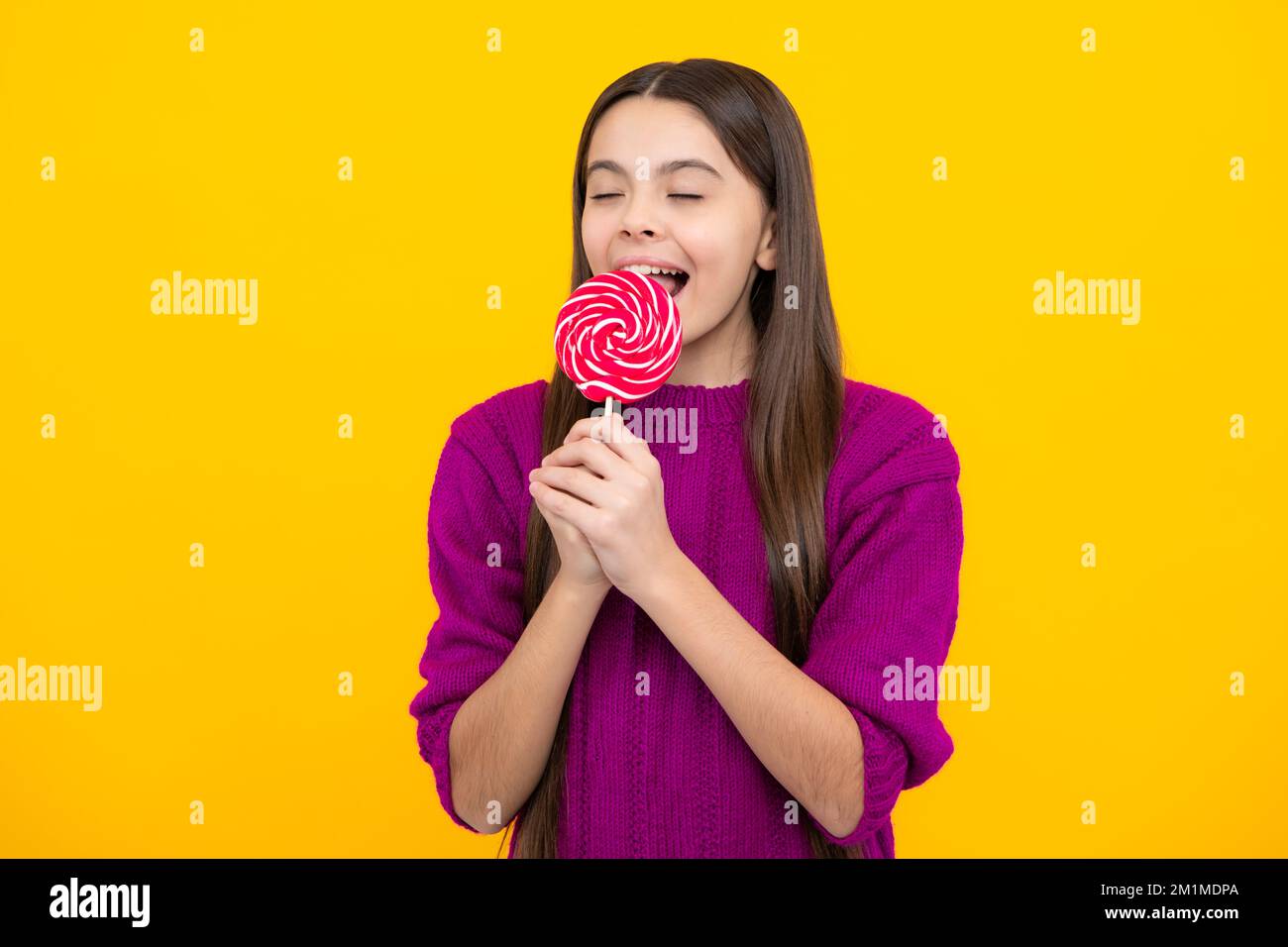 Funny child with lollipop over yellow isolated background. Sweet ...