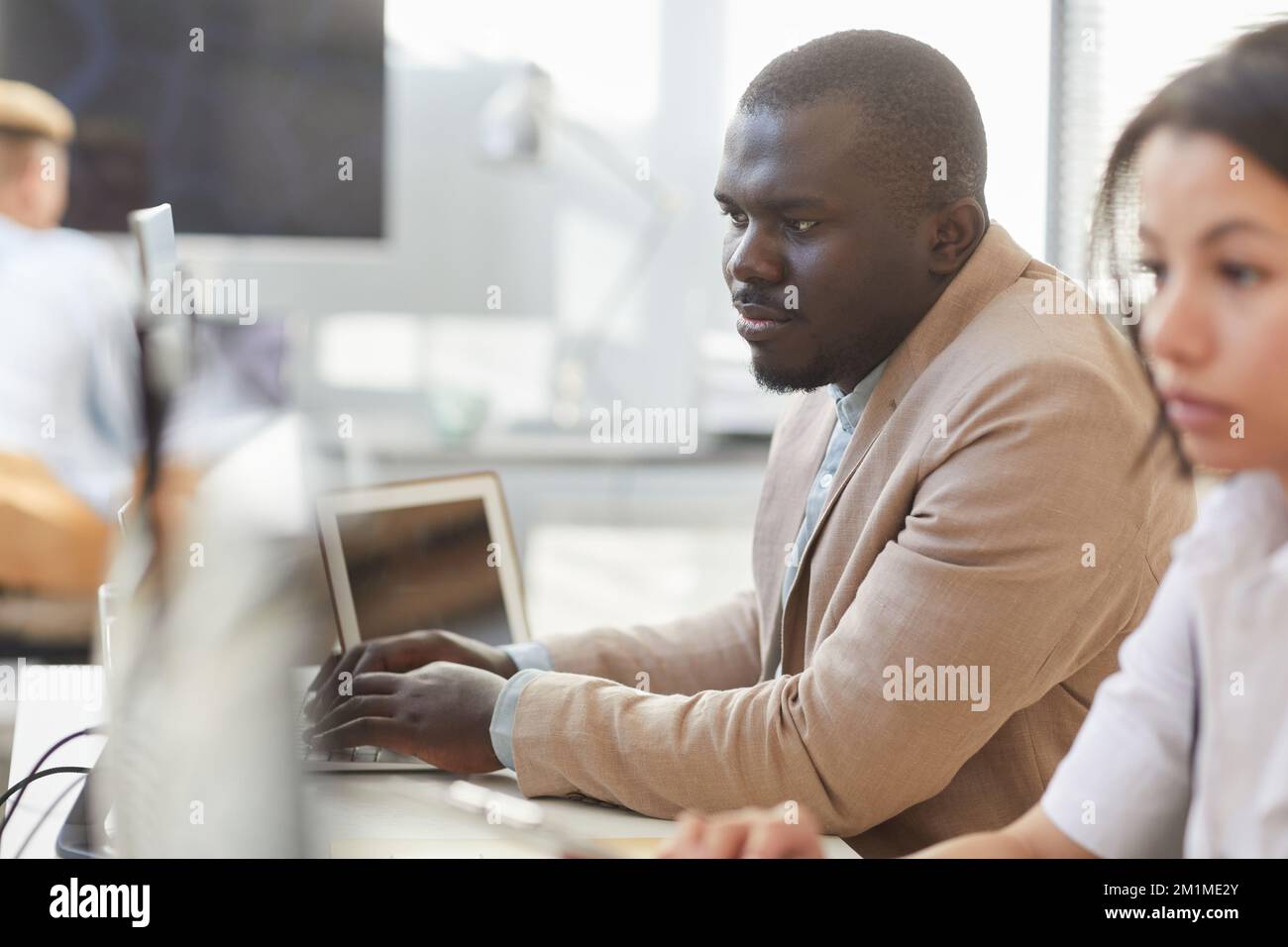 Side view portrait of black man using laptop while sitting in row in ...