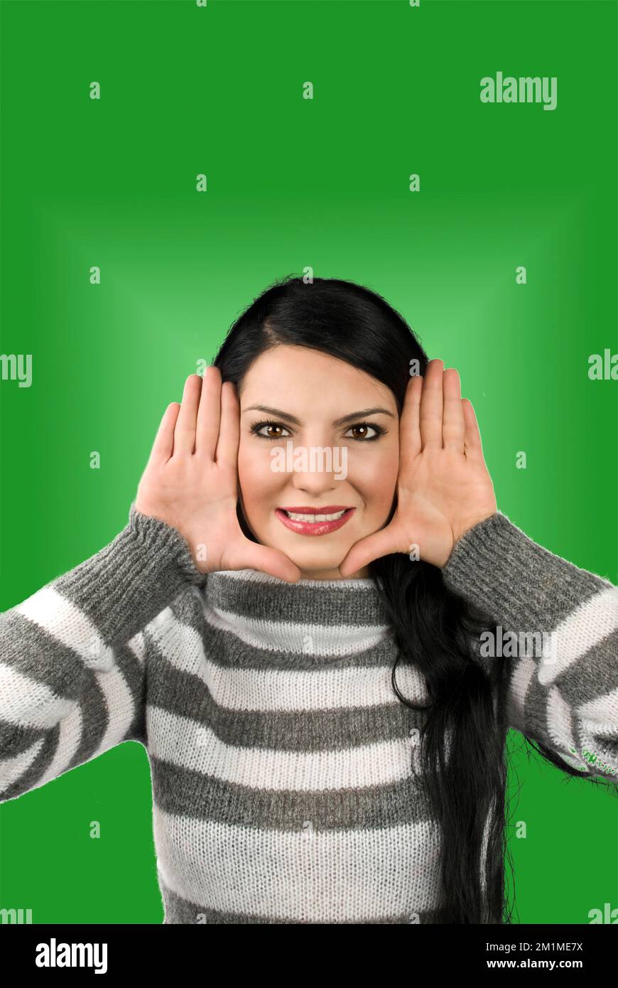Beautiful woman frame her face with hands and fingers are tightly and ...