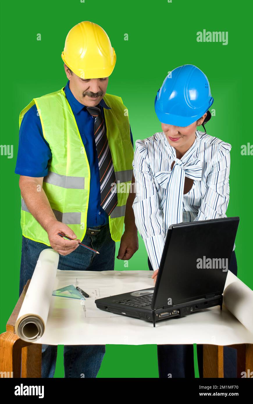 Two architects in office looking on plans , working with notebook and ...