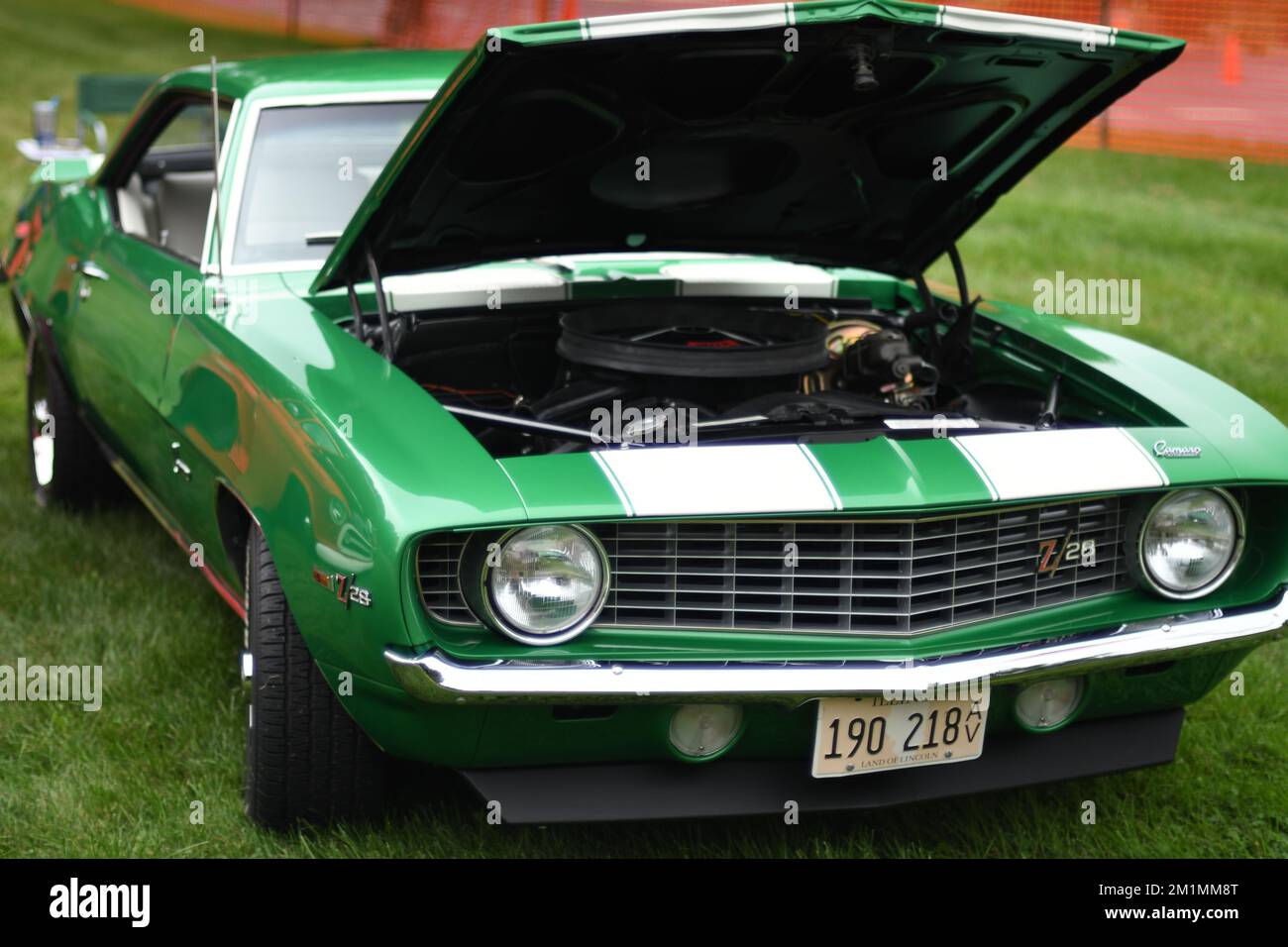 A closeup shot of a green Chevrolet Camaro with the hood opened at ...