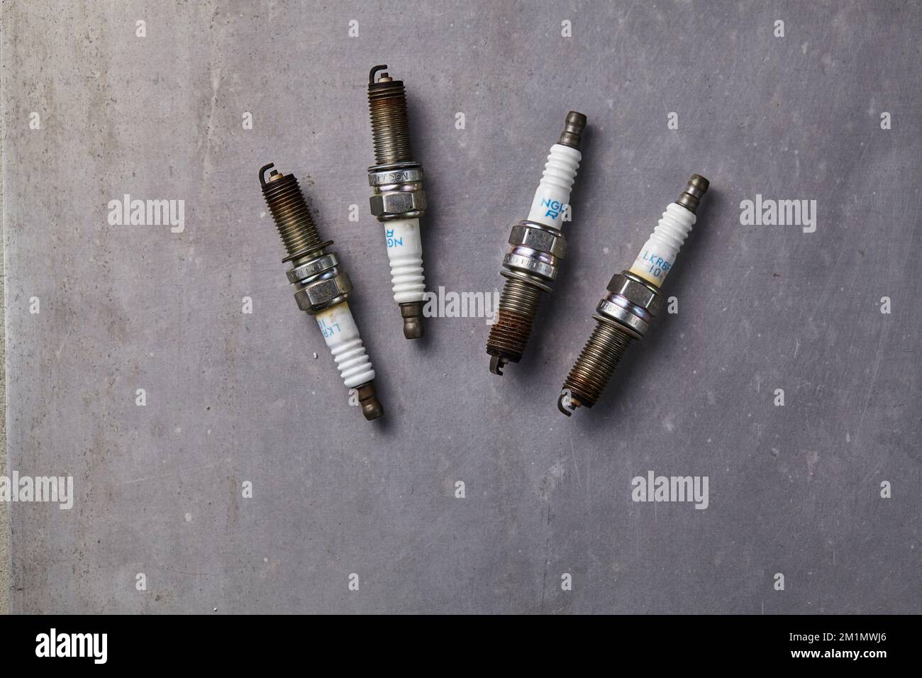 four used car spark plugs that are dirty and time to be replaced Stock ...