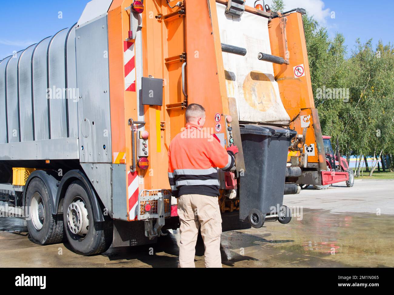Worker of urban municipal recycling garbage collector truck loading ...