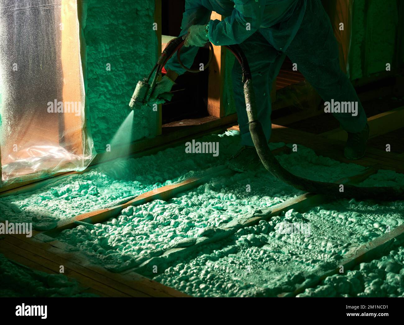Male builder insulating wooden frame house. Cropped view of man worker ...
