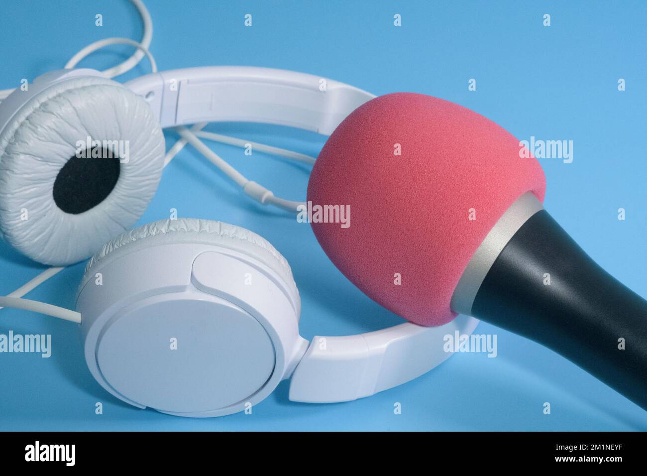 White headphones and microphone with red filter cap for speaking and ...