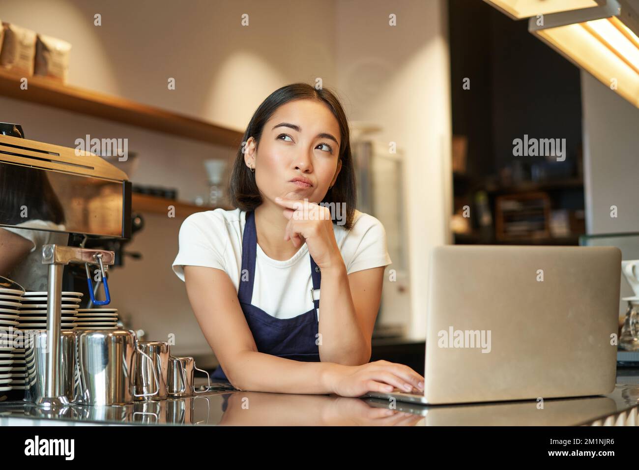 Portrait of girl barista with laptop, standing at counter in coffee ...
