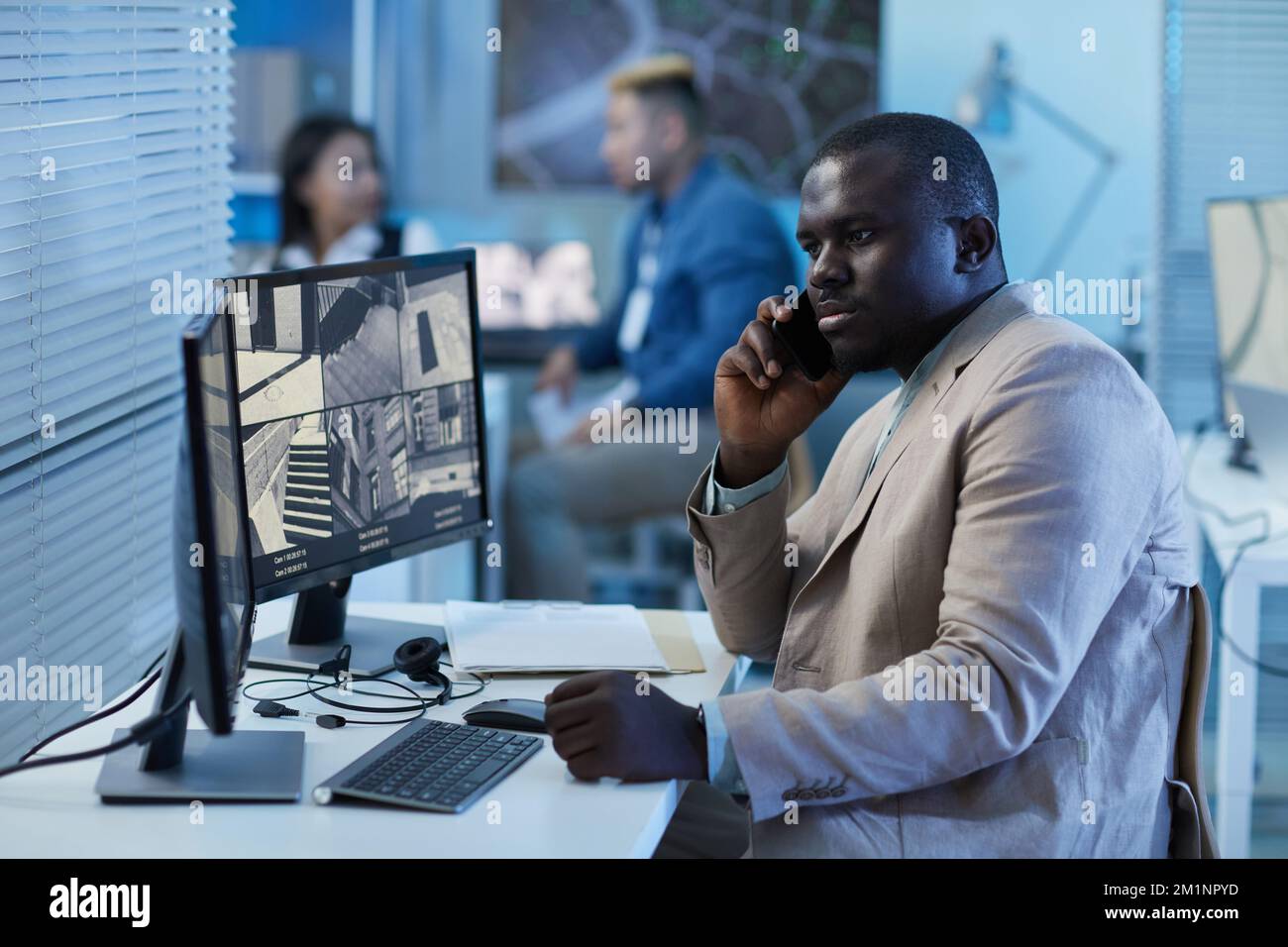Side view portrait of black man speaking on phone and looking at ...