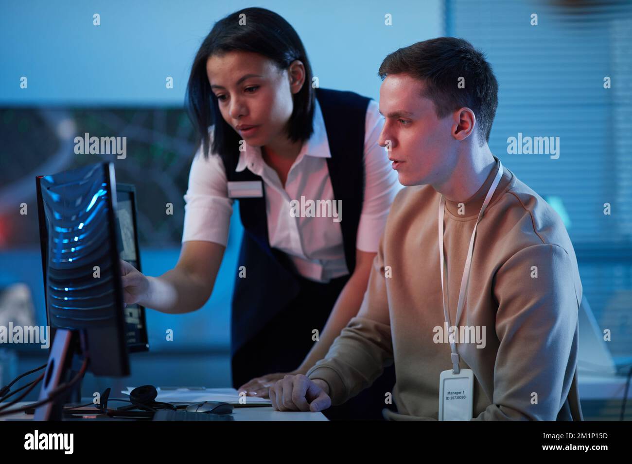 Side view portrait of two young people looking at surveillance camera ...
