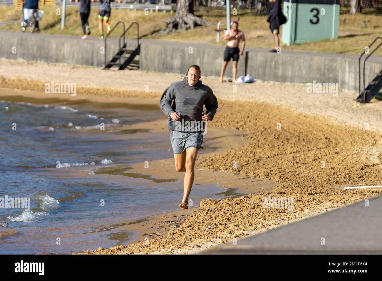 Motala Sweden July 2022 Young man running on the beach while listen to ...