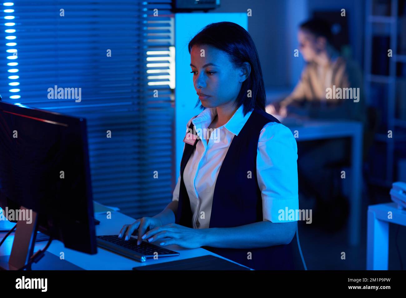 Side view portrait of young woman watching surveillance camera feed in ...