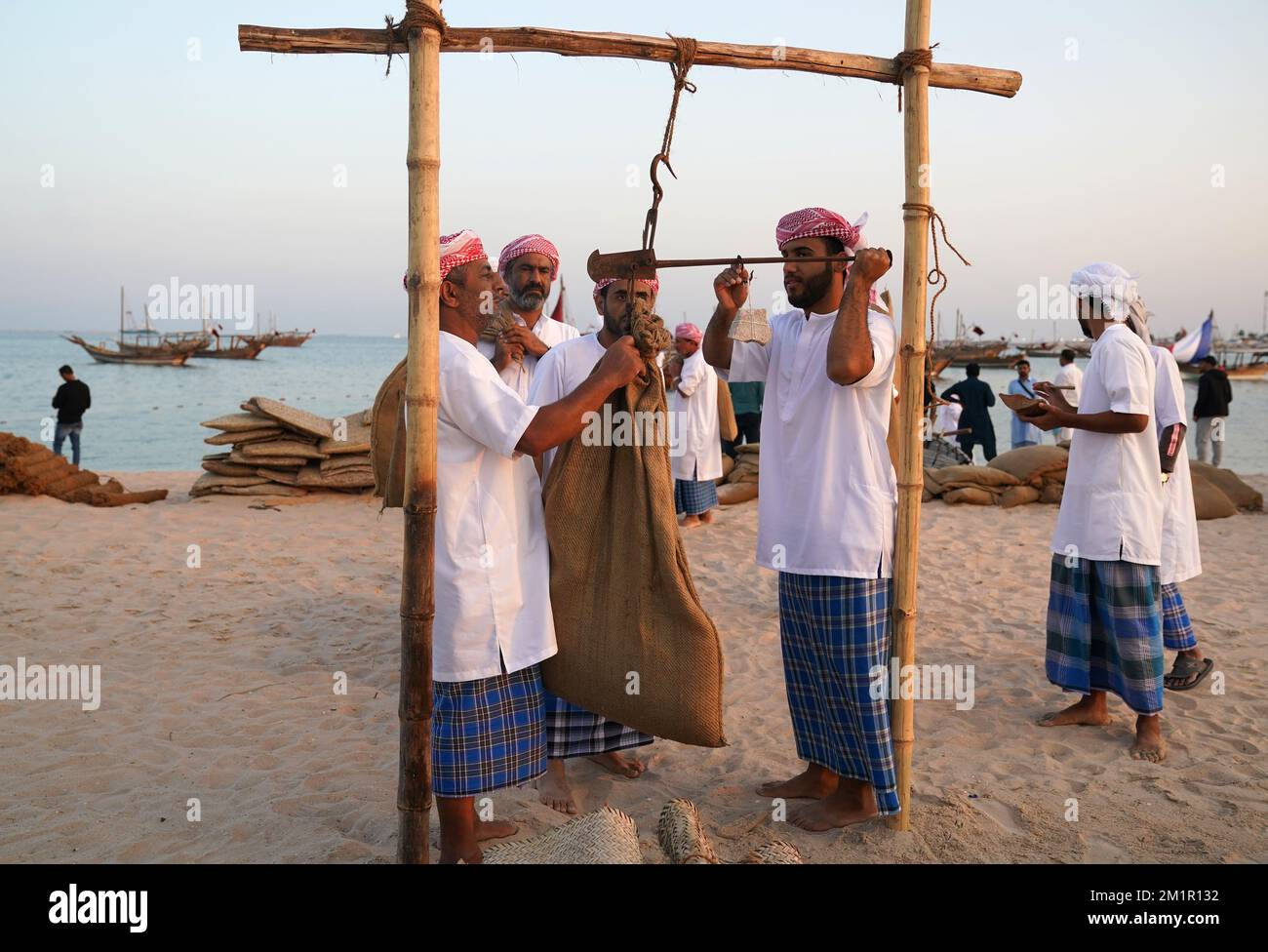 Fishermen weigh caught fish on the beach at Katara Cultural Village in ...