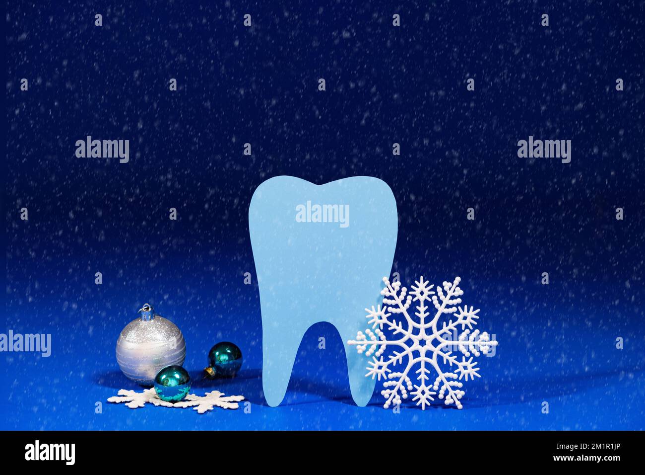 Christmas dentistry - tooth, snowflakes and balls on a blue festive ...