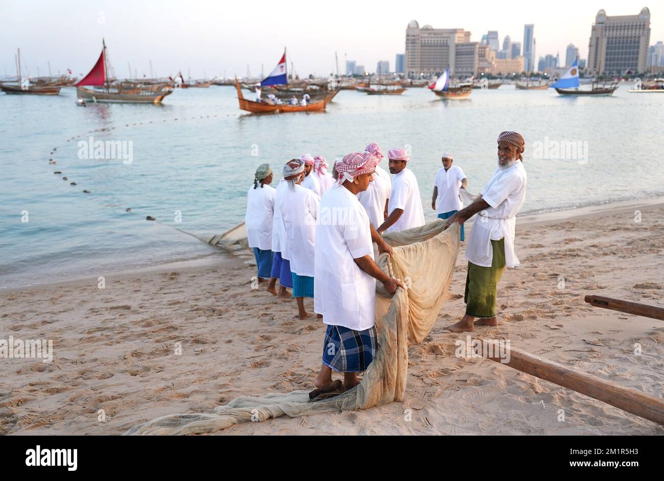 Fisherman bring in a large net with fish at the Katara Cultural Village ...