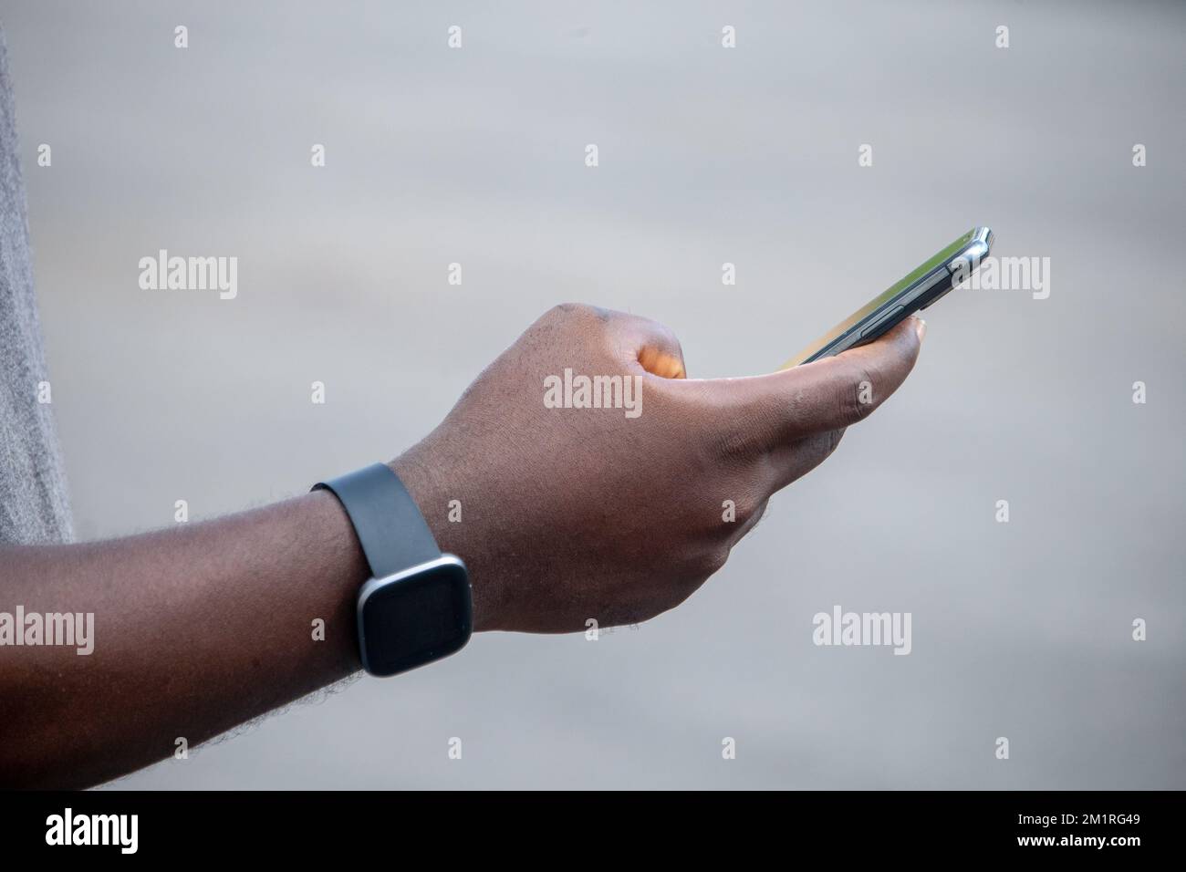 Hand of young black african man holding white blank screen smartphone ...