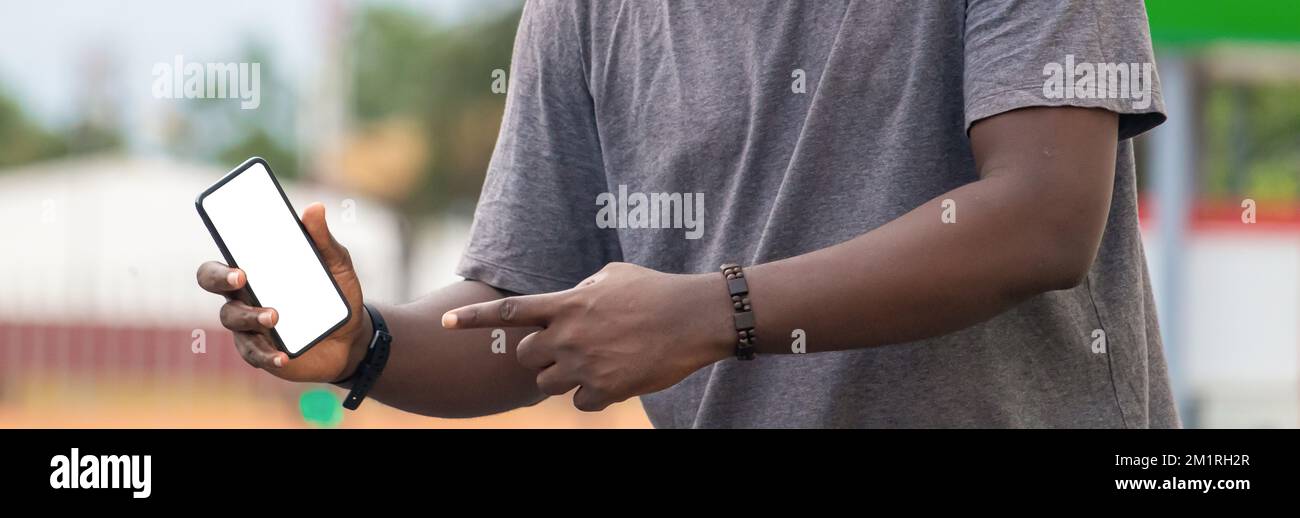 Hand of young black african man holding white blank screen smartphone ...