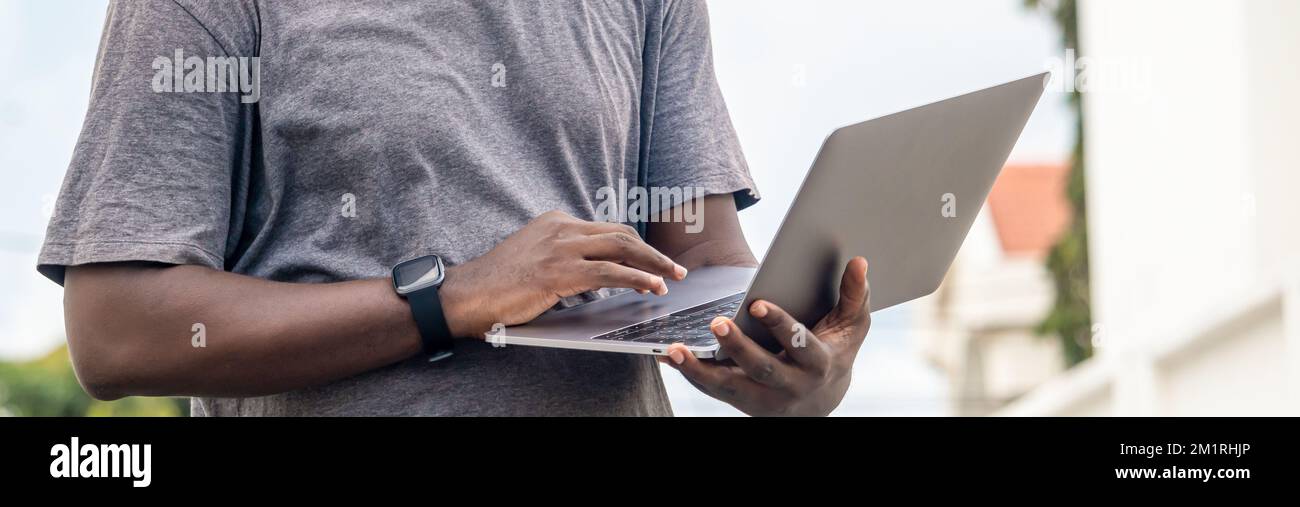 Side view, African web developer works with his laptop Stock Photo - Alamy