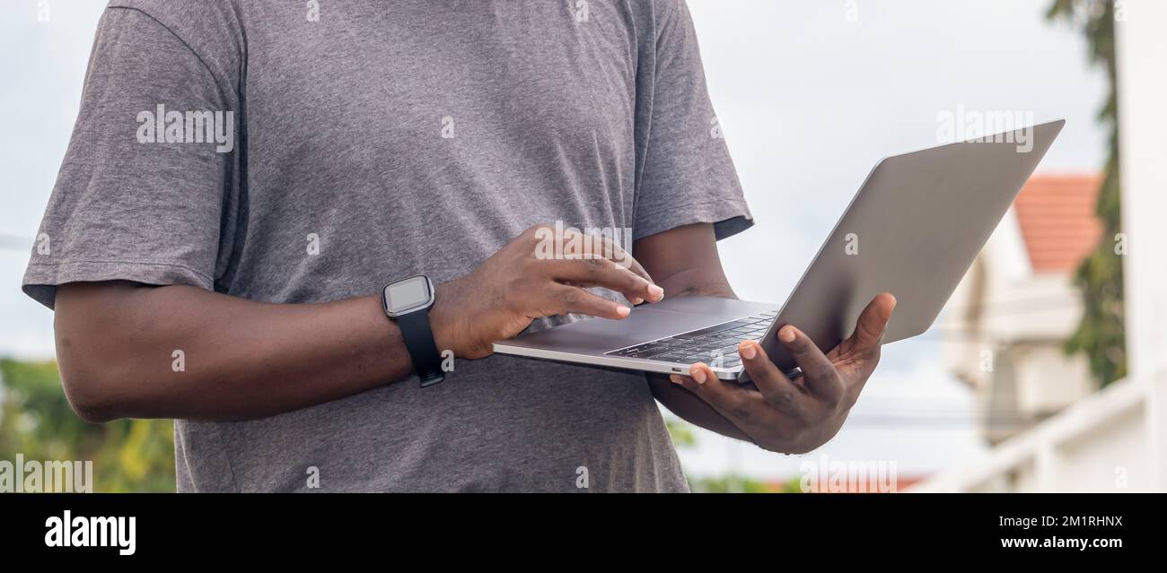 Side view, African web developer works with his laptop Stock Photo - Alamy