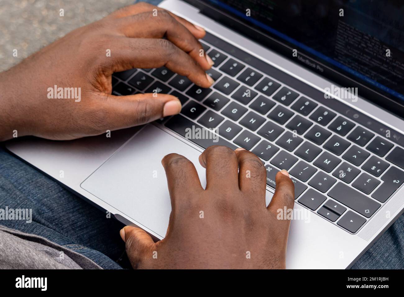 Hand portrait of an African web developer working with his laptop, with ...