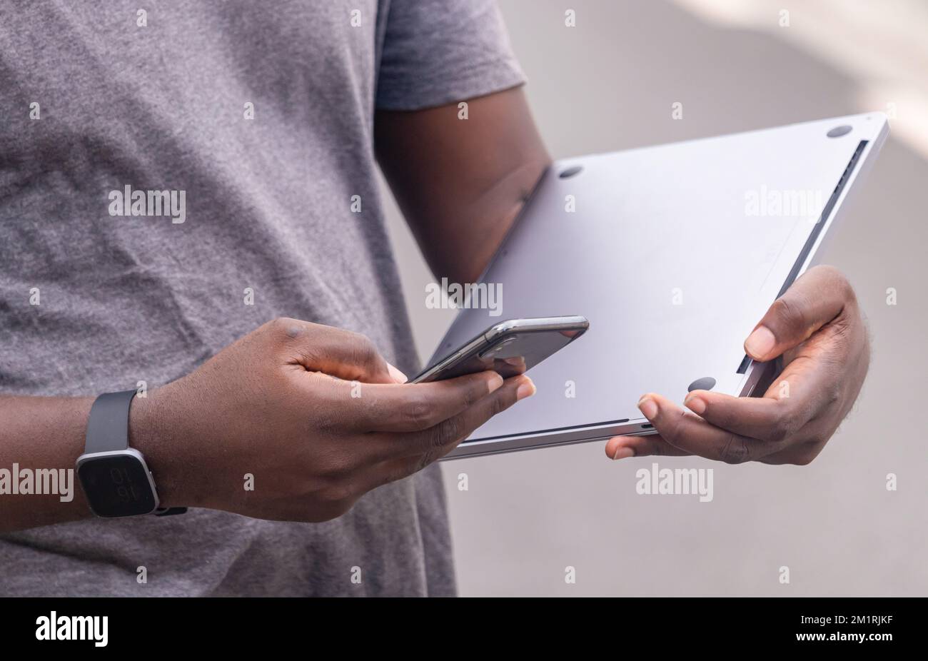 African man hand reading text message on mobile phone while in urban ...