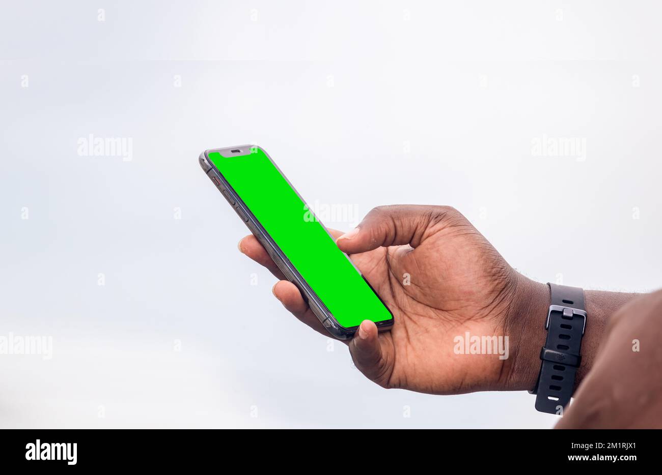 African man hand reading text message on mobile phone while in urban ...