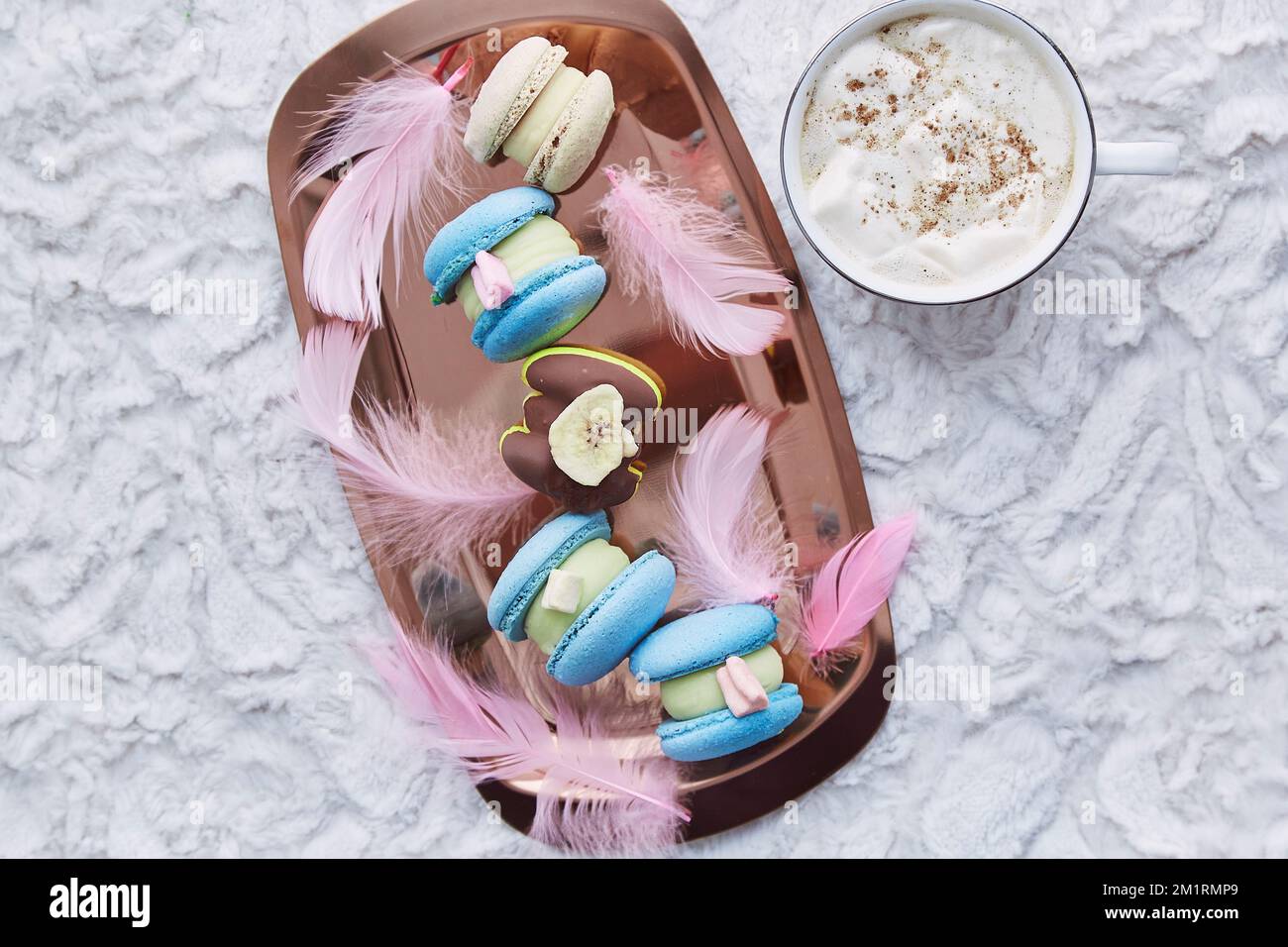 Aesthetic blue and yellow delicate macaroons on the golden tray among ...
