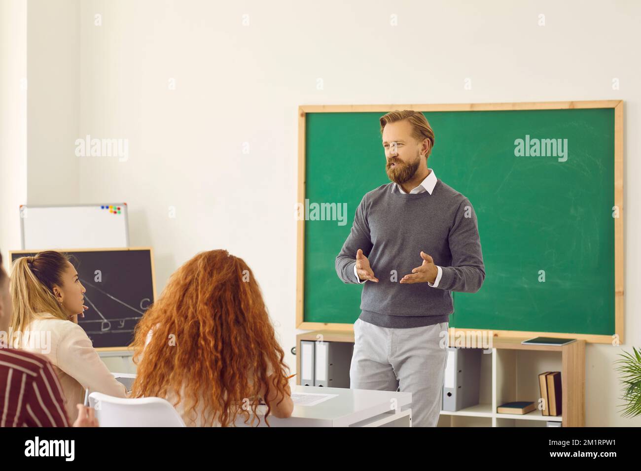 Portrait of happy male professor during class with chalk board on ...