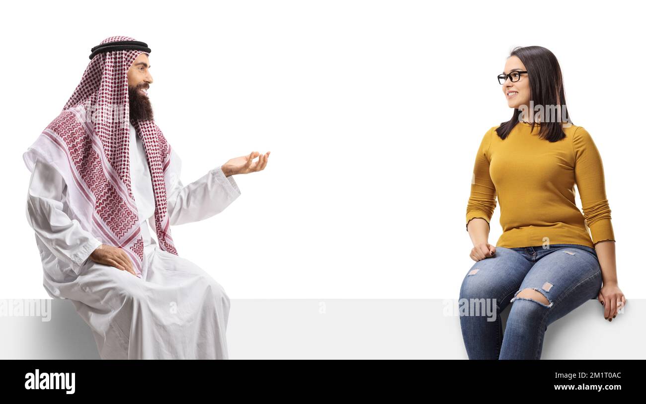 Arab man in a traditional thobe talkign to a young female and sitting ...