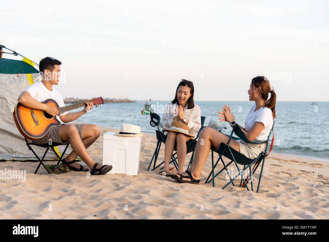 Happy friend have fun playing guitar and clap in camp they smiling ...