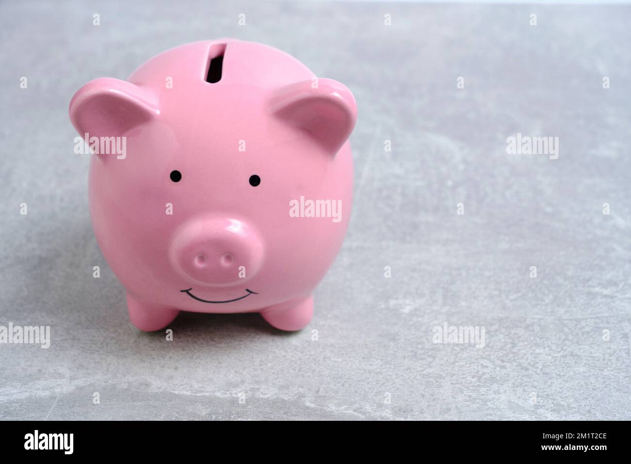 Pink piggy bank light concrete background Stock Photo - Alamy