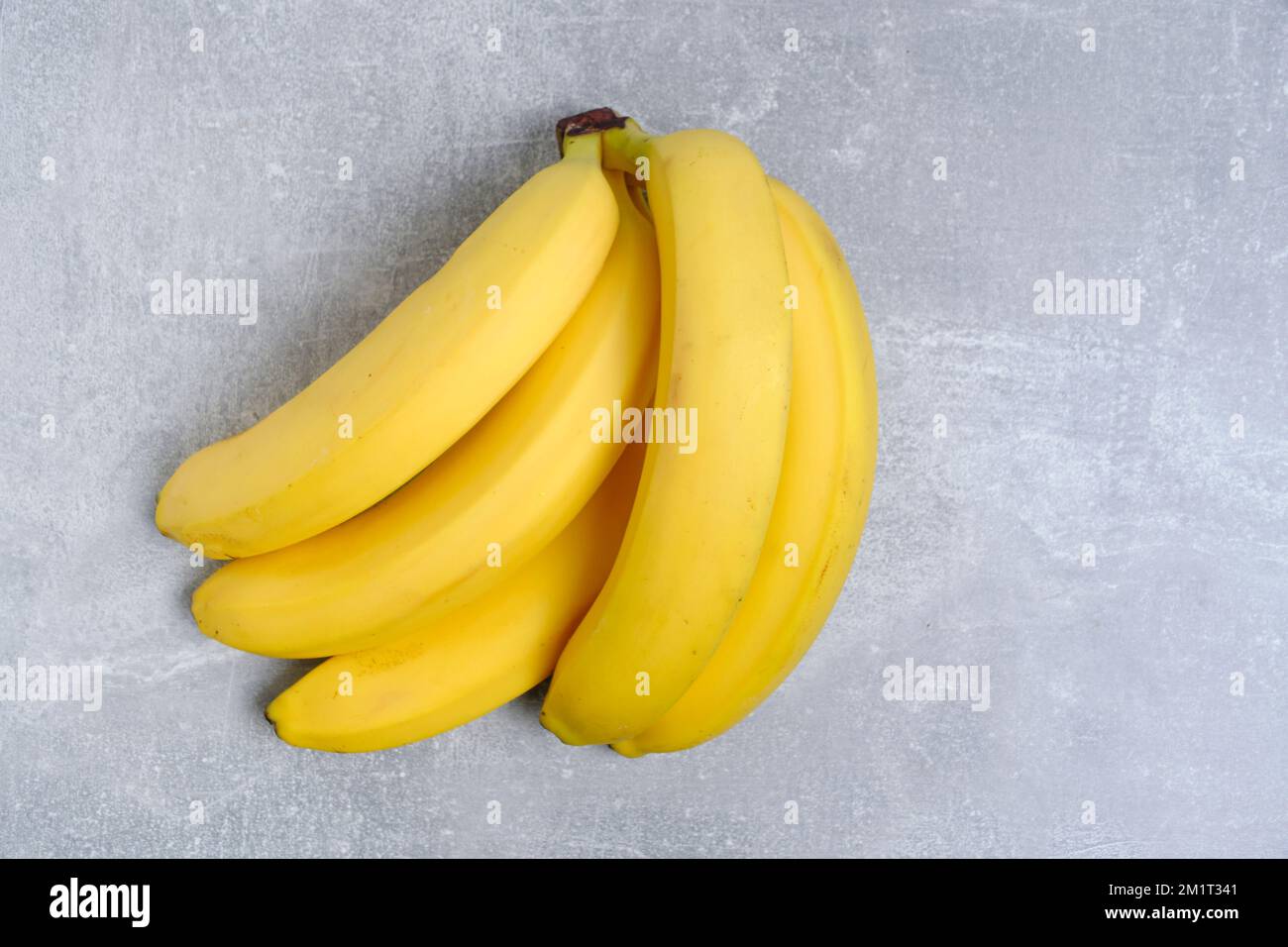 Bunch ripe, yellow bananas gray concrete background Stock Photo - Alamy