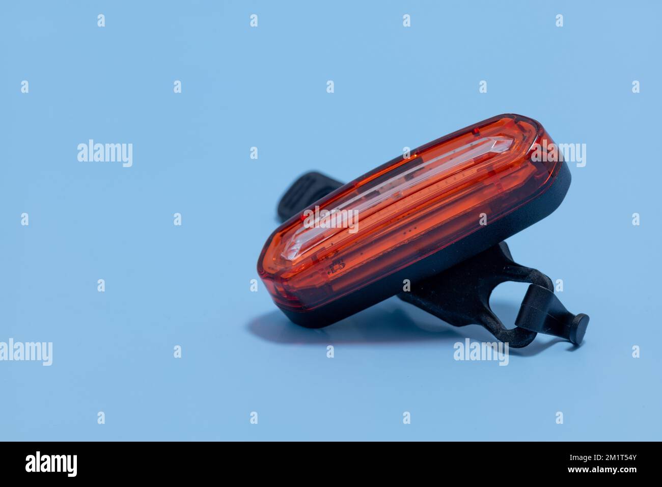 A closeup shot of a red bicycle light with a black fixing belt on a ...