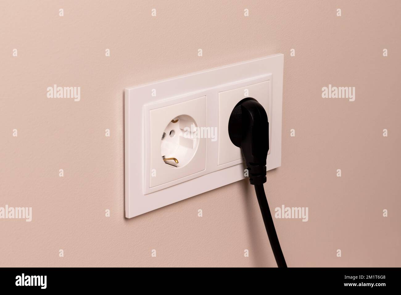 Group of white european electrical outlets with black plug inserted ...