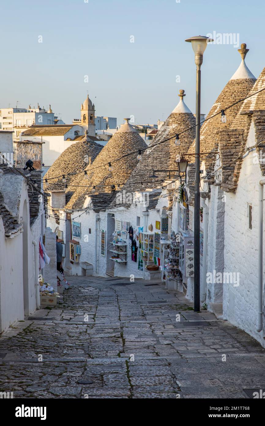 Whitewashed trulli houses along street in the old town, Alberobello ...