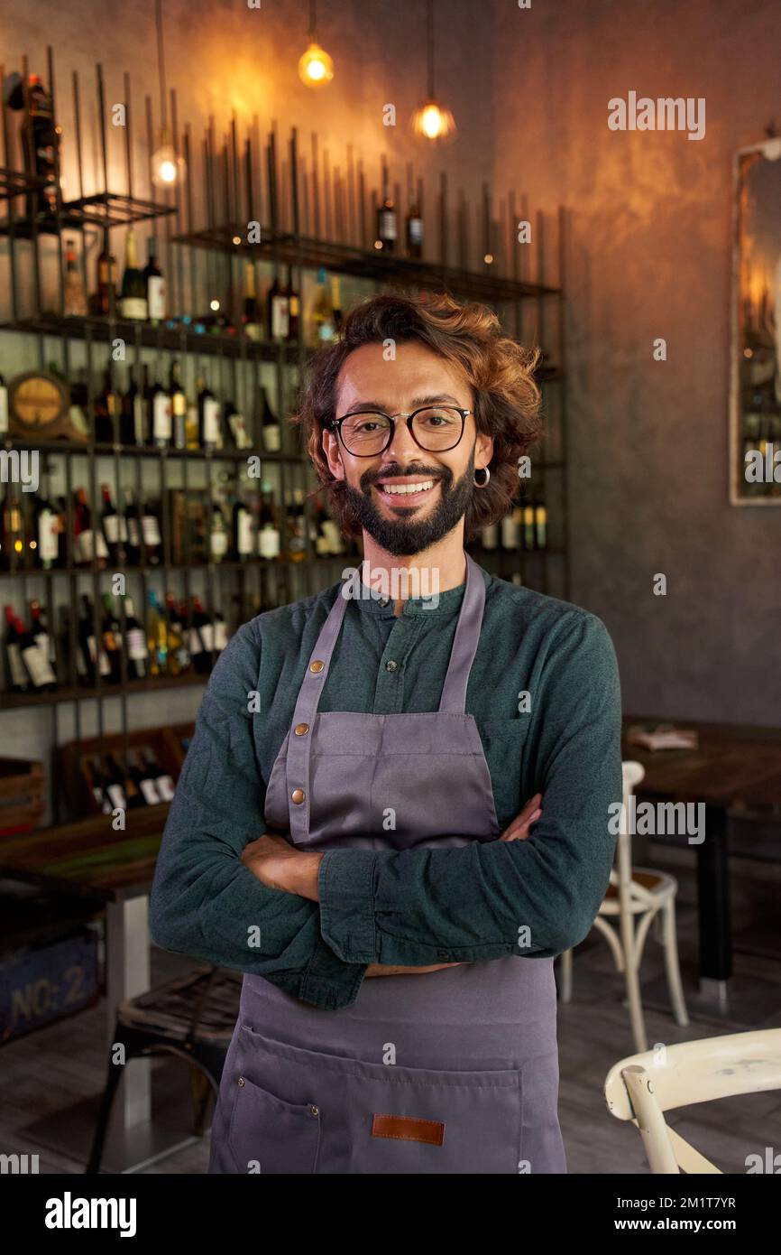 Vertical portrait Looking at camera portrait of young owner of a small ...