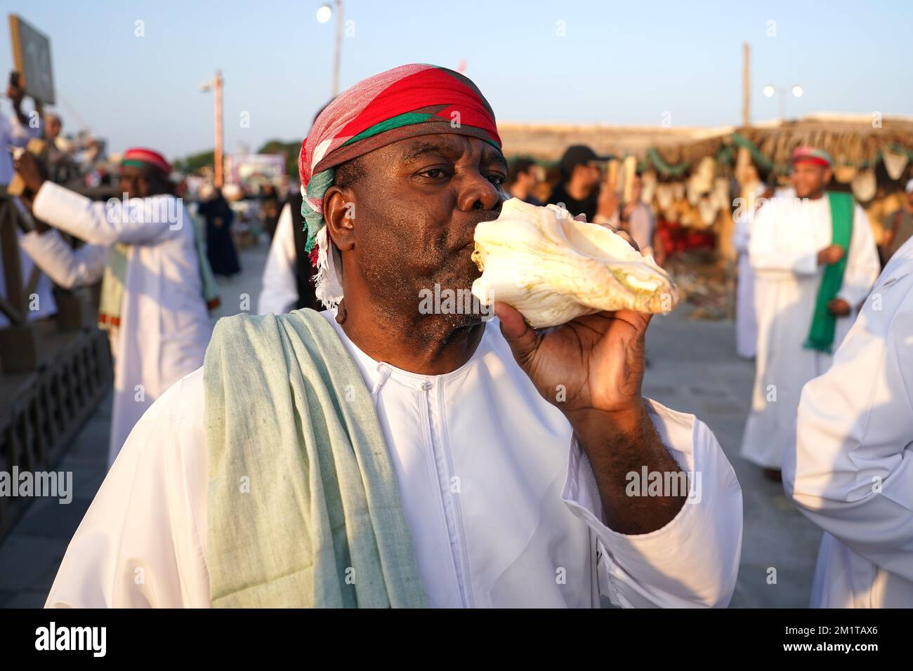A local person blows into a sea shell in the Katara Cultural Village in ...