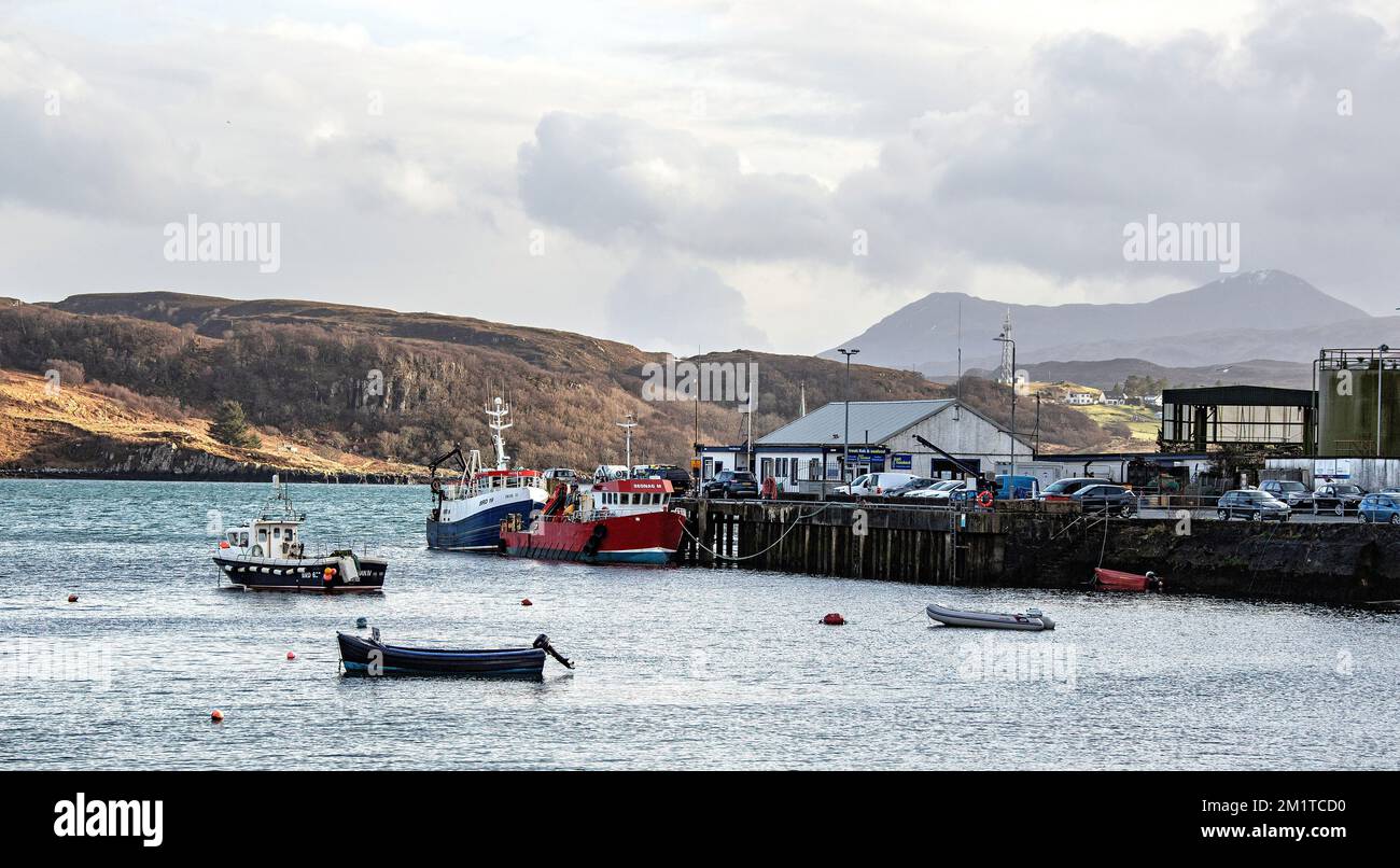 Boats at anchor and alongside the wharf in Portree Harbour on the Isle ...