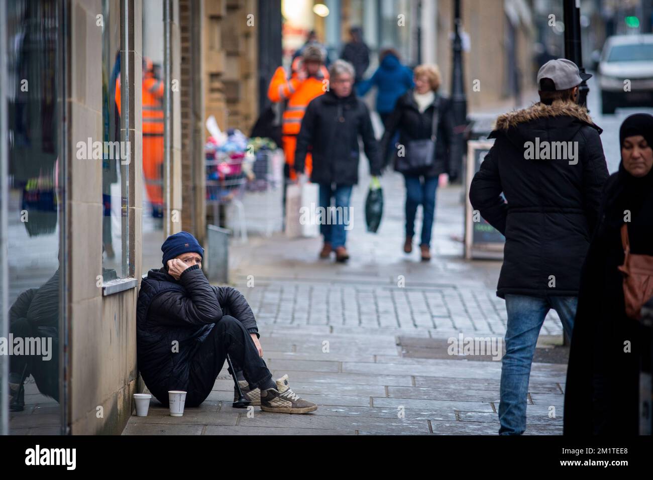 A man begging for money on a town centre shopping street in Halifax ...